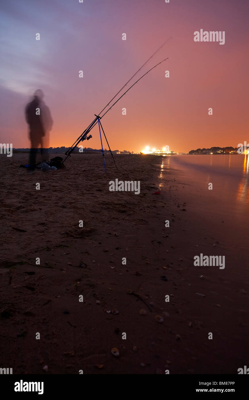 Angler night fishing from the beach at Swanage in Dorset, Uk Stock ...