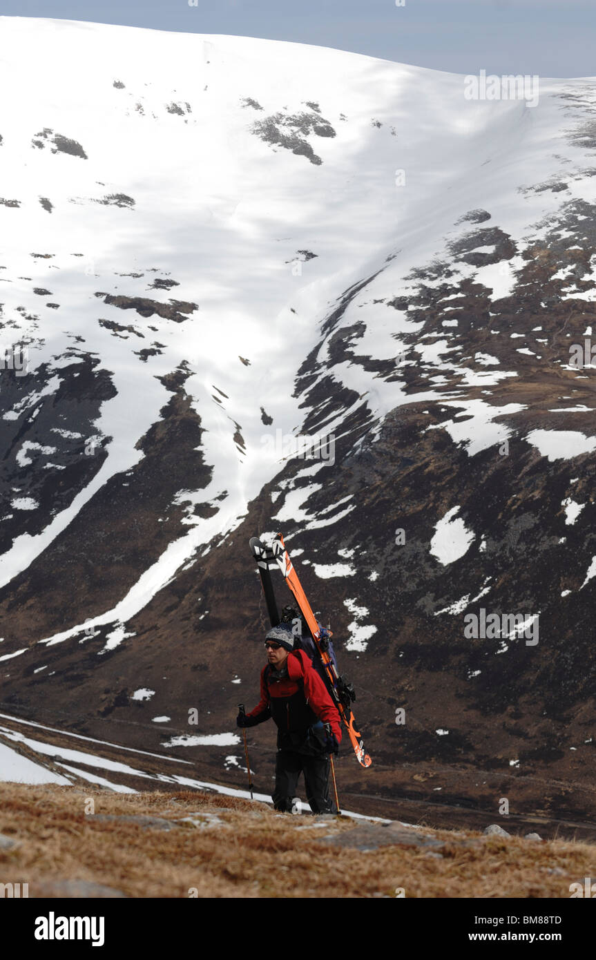 A man carrying a heavy Rucksack and skis in the Cairngorms Scotland ...
