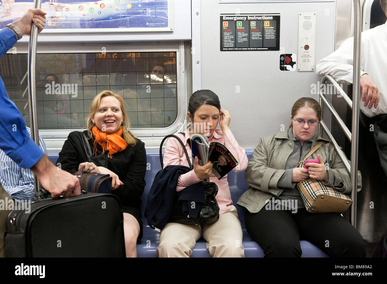 fluorescent lit interior of late model New York subway train with three ...