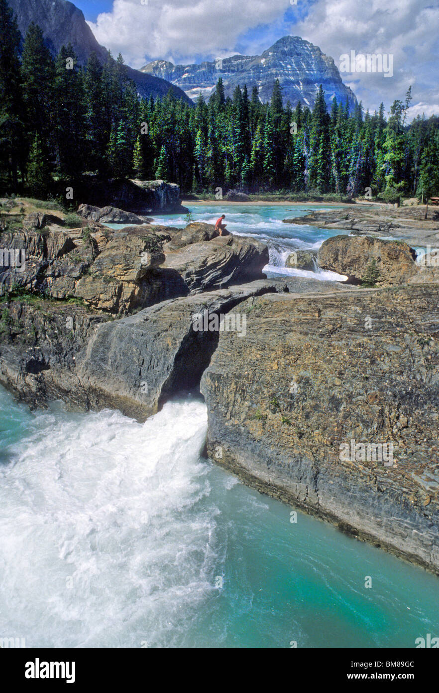 River full of glacial silt flows through huge crack in rock in Canadian ...