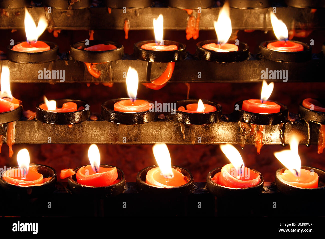 Red votive candles burning as an offering inside church of Basilica of ...
