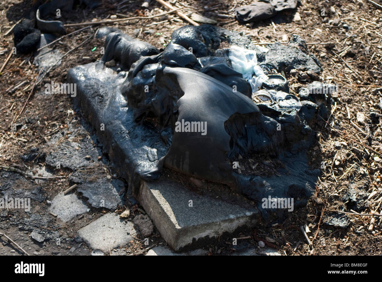The remains of a plastic litter bin that has been set on fire Stock ...