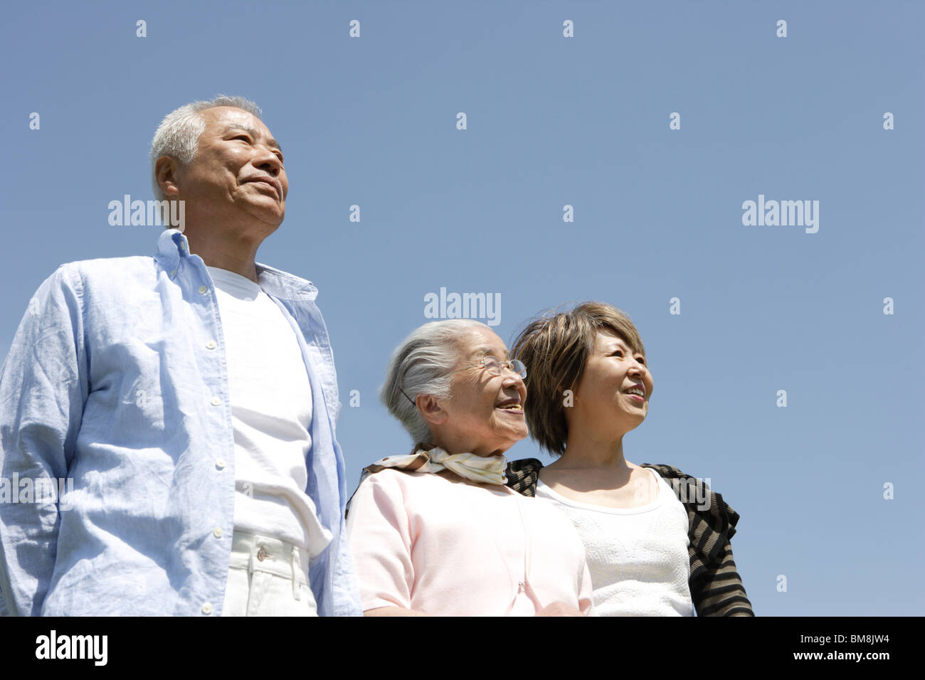 Two generation family against sky, smiling, blue background Stock Photo ...