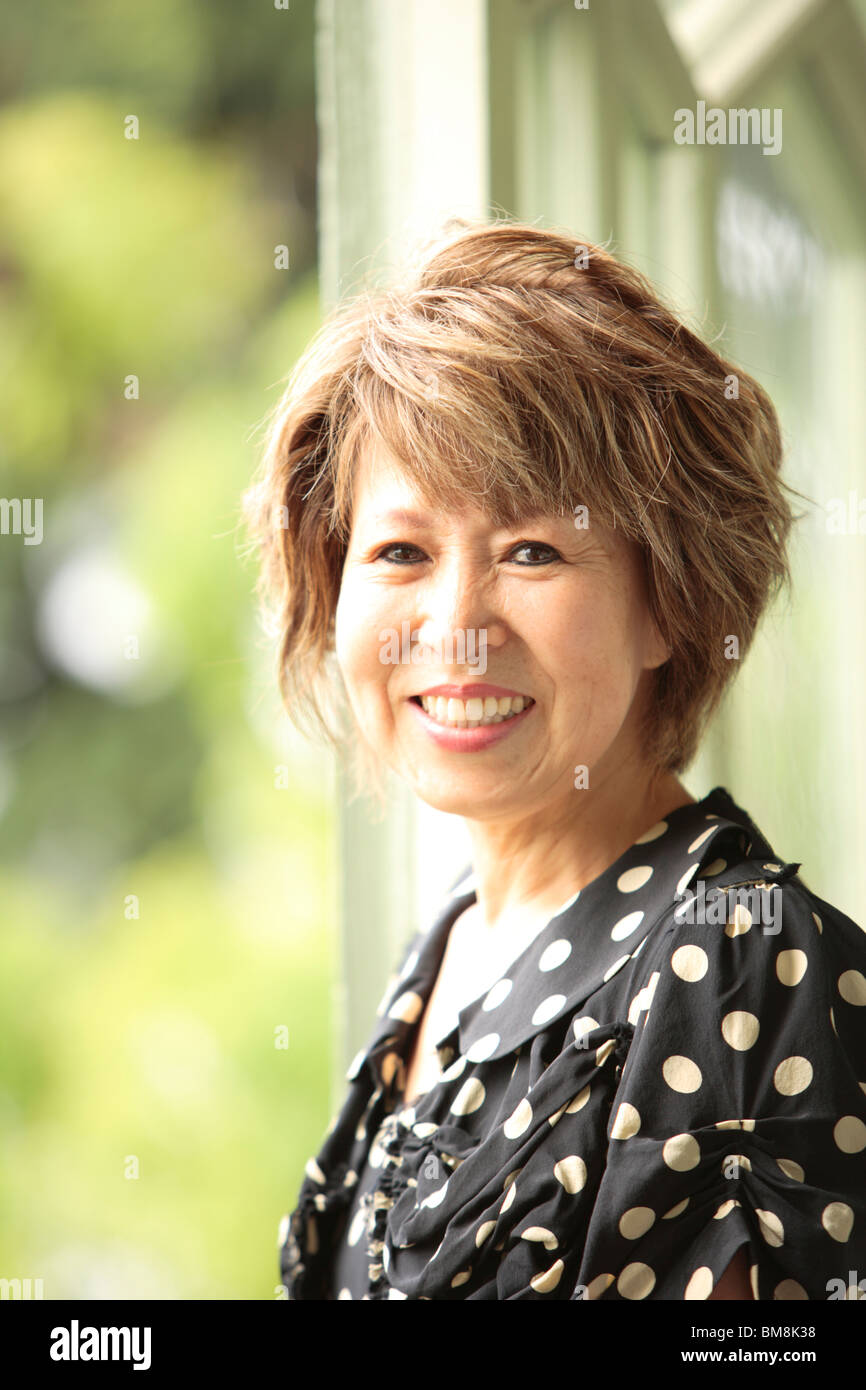 Portrait of mature woman by window, smiling Stock Photo - Alamy