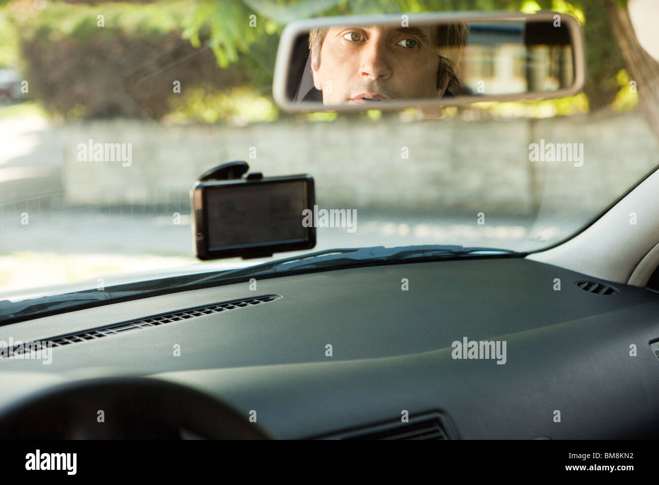 Driver checking rear-view mirror Stock Photo - Alamy