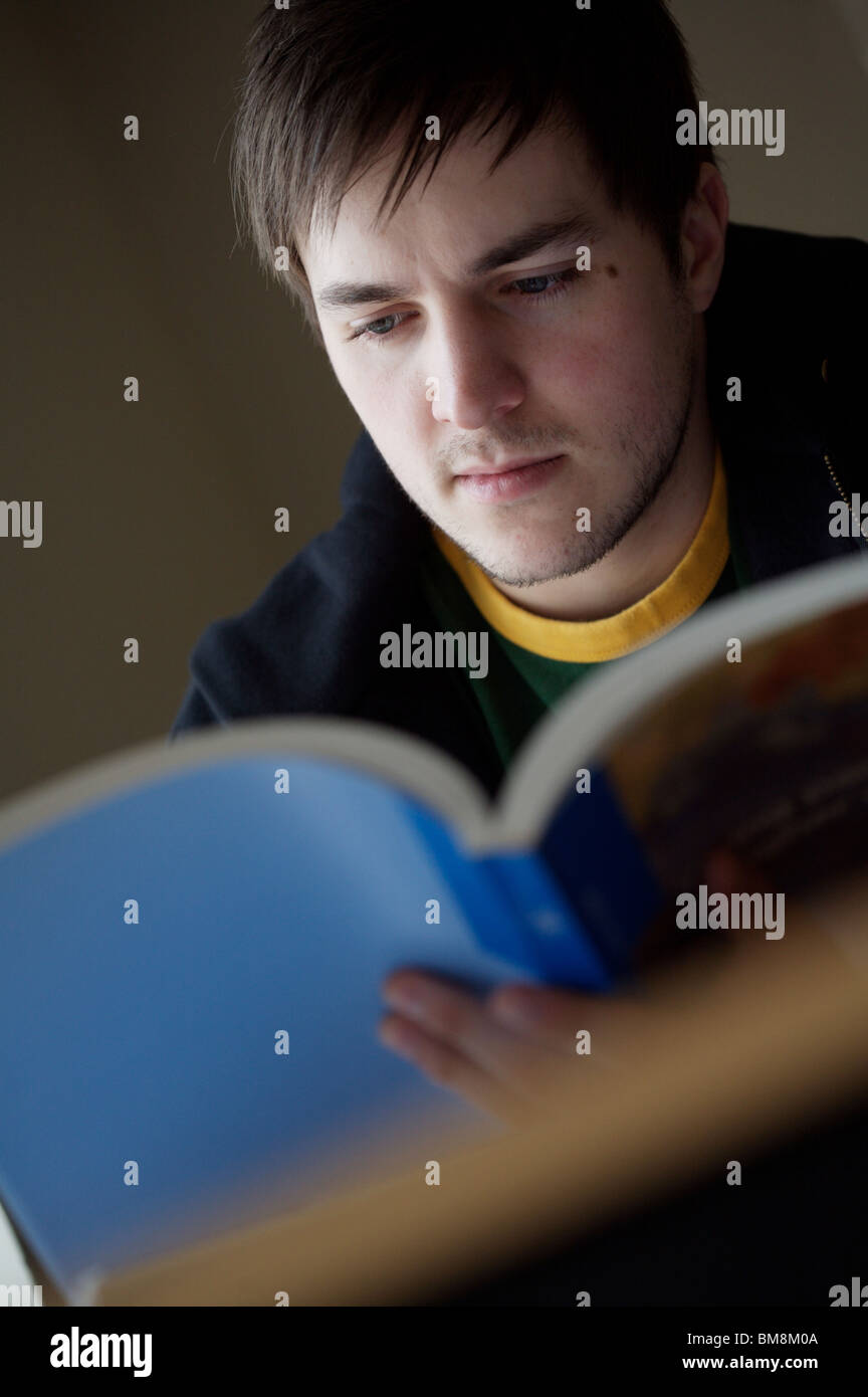 Male Student studying book in library Stock Photo - Alamy