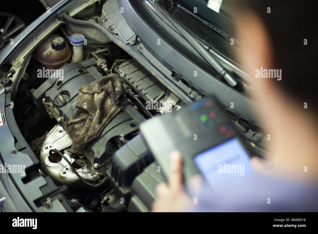 Mechanic working on car engine Stock Photo - Alamy