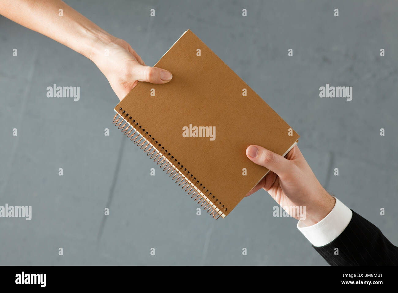 Handing colleague notebook Stock Photo - Alamy
