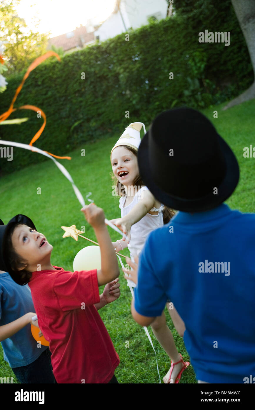 Children pulling streamers attached to pull string pinata Stock Photo ...
