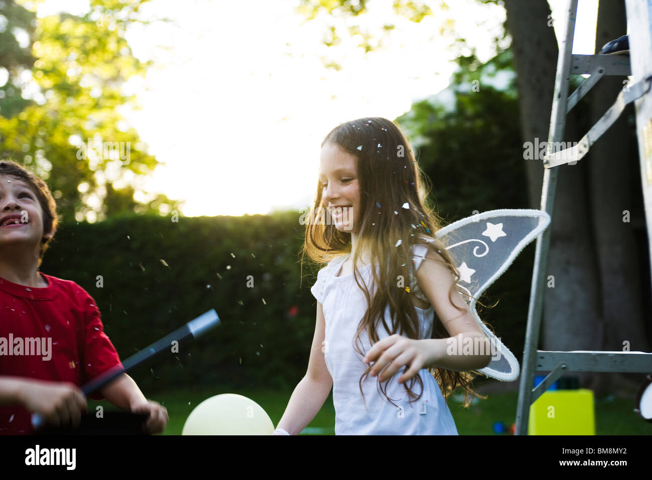 Children having fun under falling confetti Stock Photo - Alamy