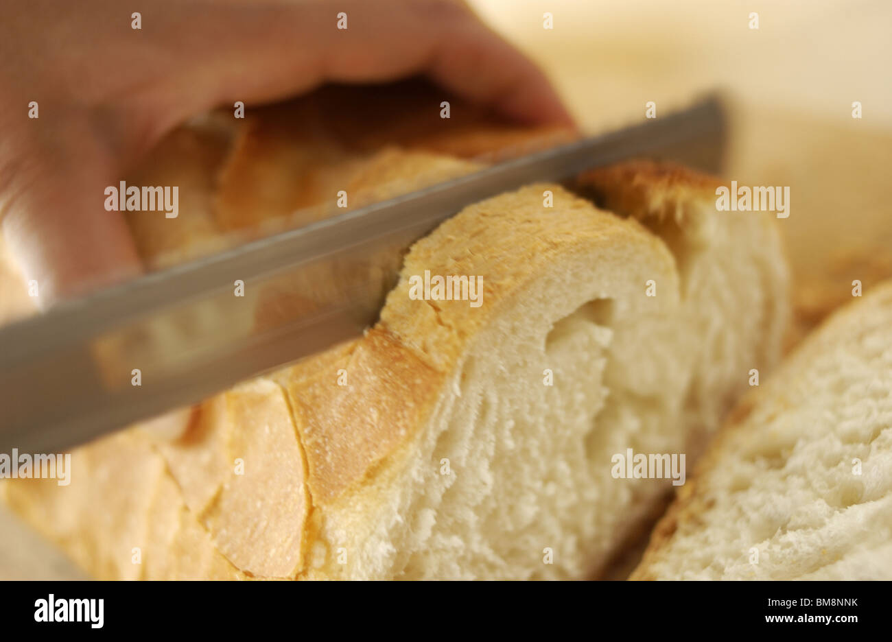 Hand slicing bread Stock Photo - Alamy