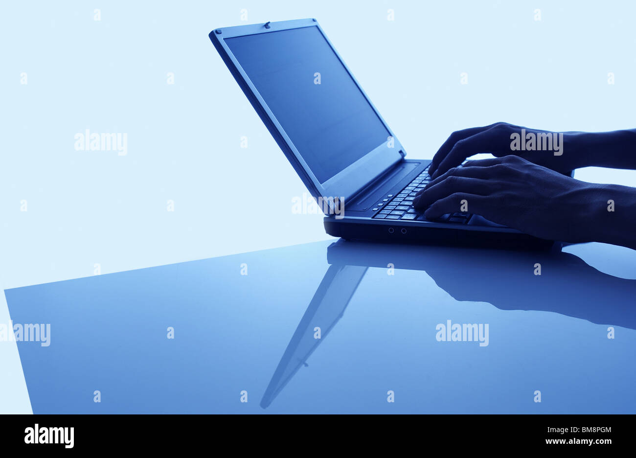 Hand using laptop blue background Stock Photo - Alamy