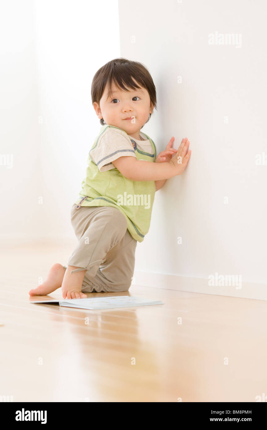 Baby boy trying to stand up Stock Photo - Alamy