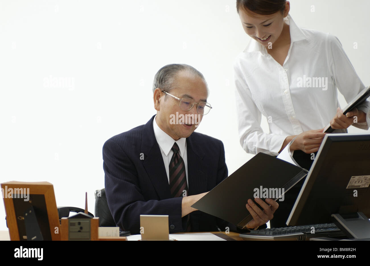 Young Woman Executive Assistant Looking at File with Her Boss Stock ...