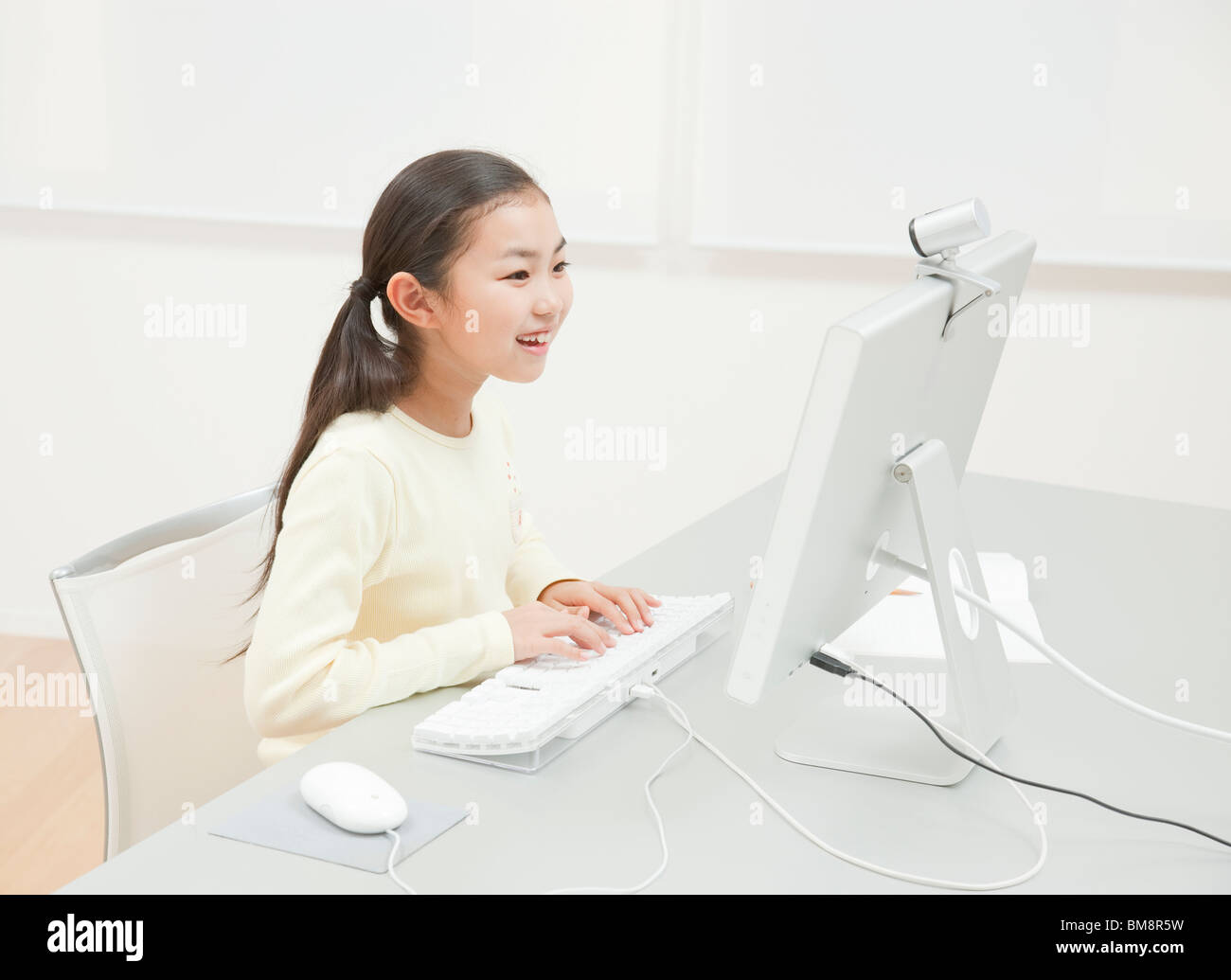 A Girl Sitting at Desk, Desktop Computer on the Desk Stock Photo - Alamy