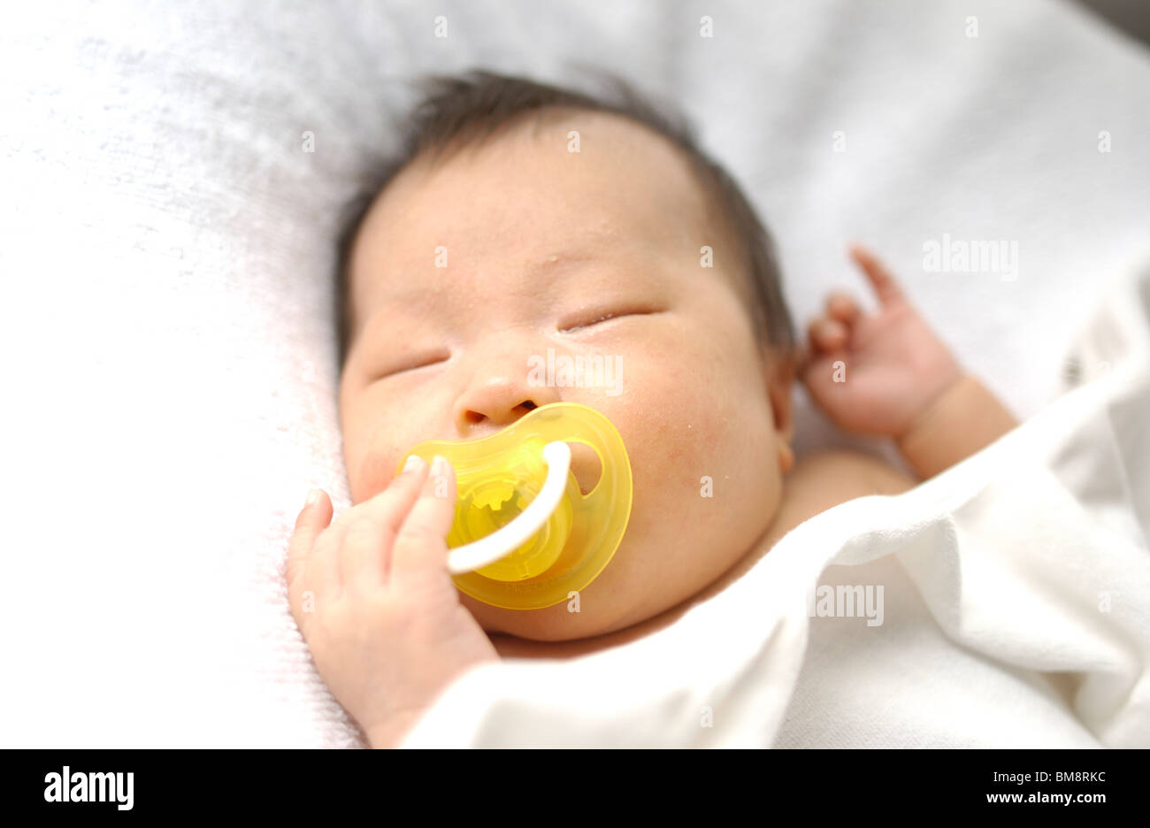 Baby with pacifier sleeping on bed, close up Stock Photo - Alamy