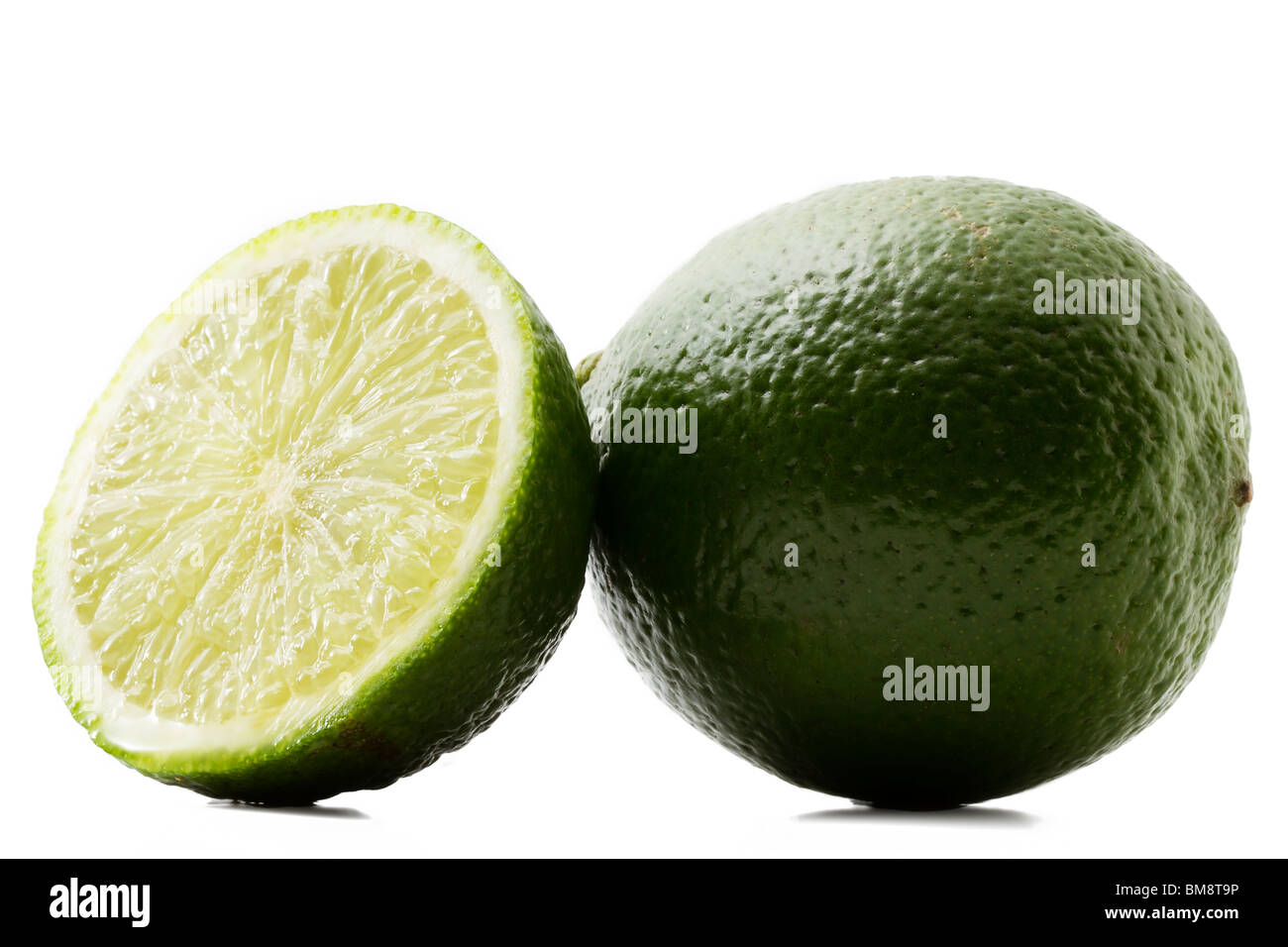 one lime and a half lime on white background Stock Photo - Alamy