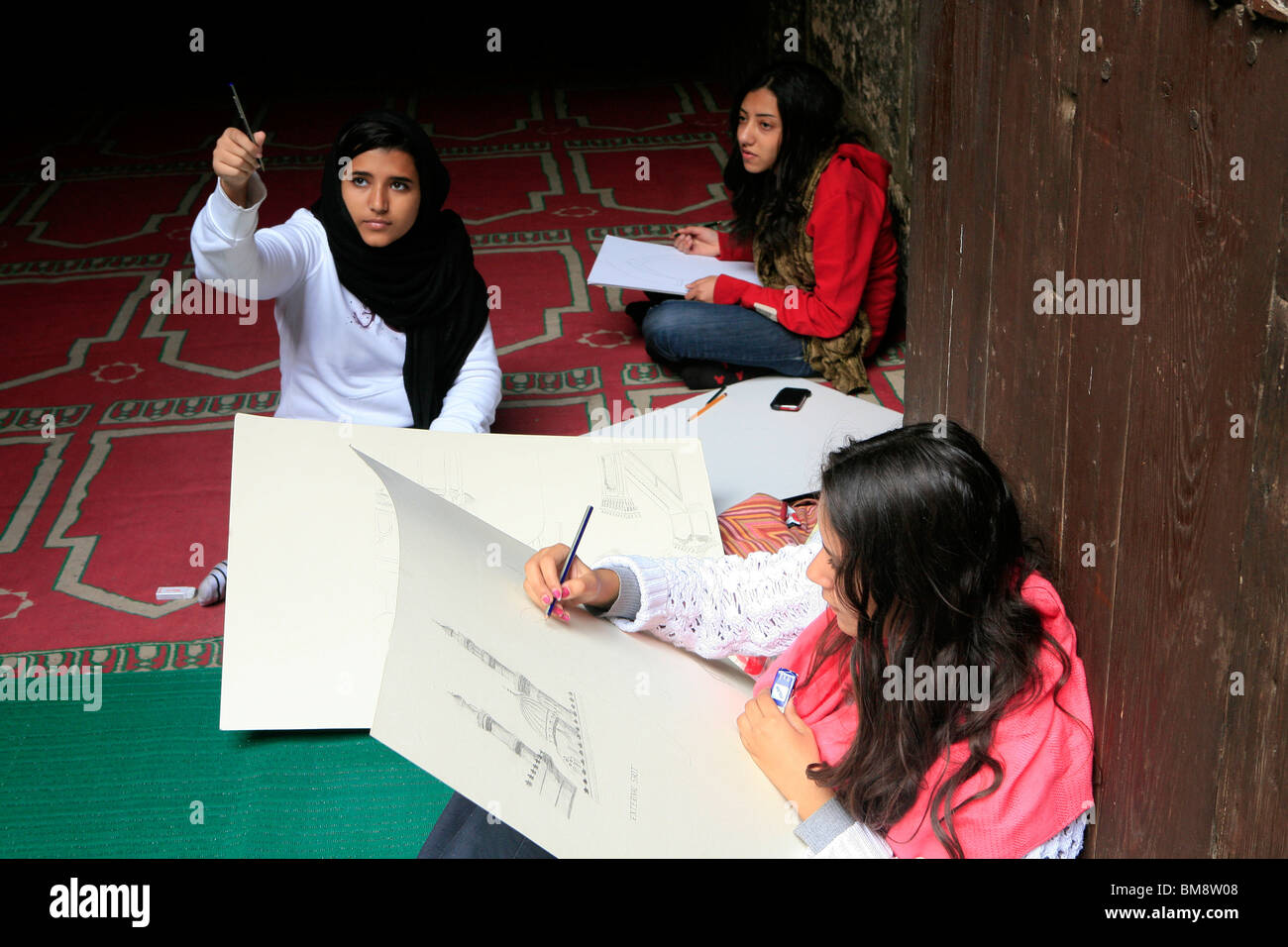 Three female art students drawing the Mosque And Madrassa Of Sultan ...