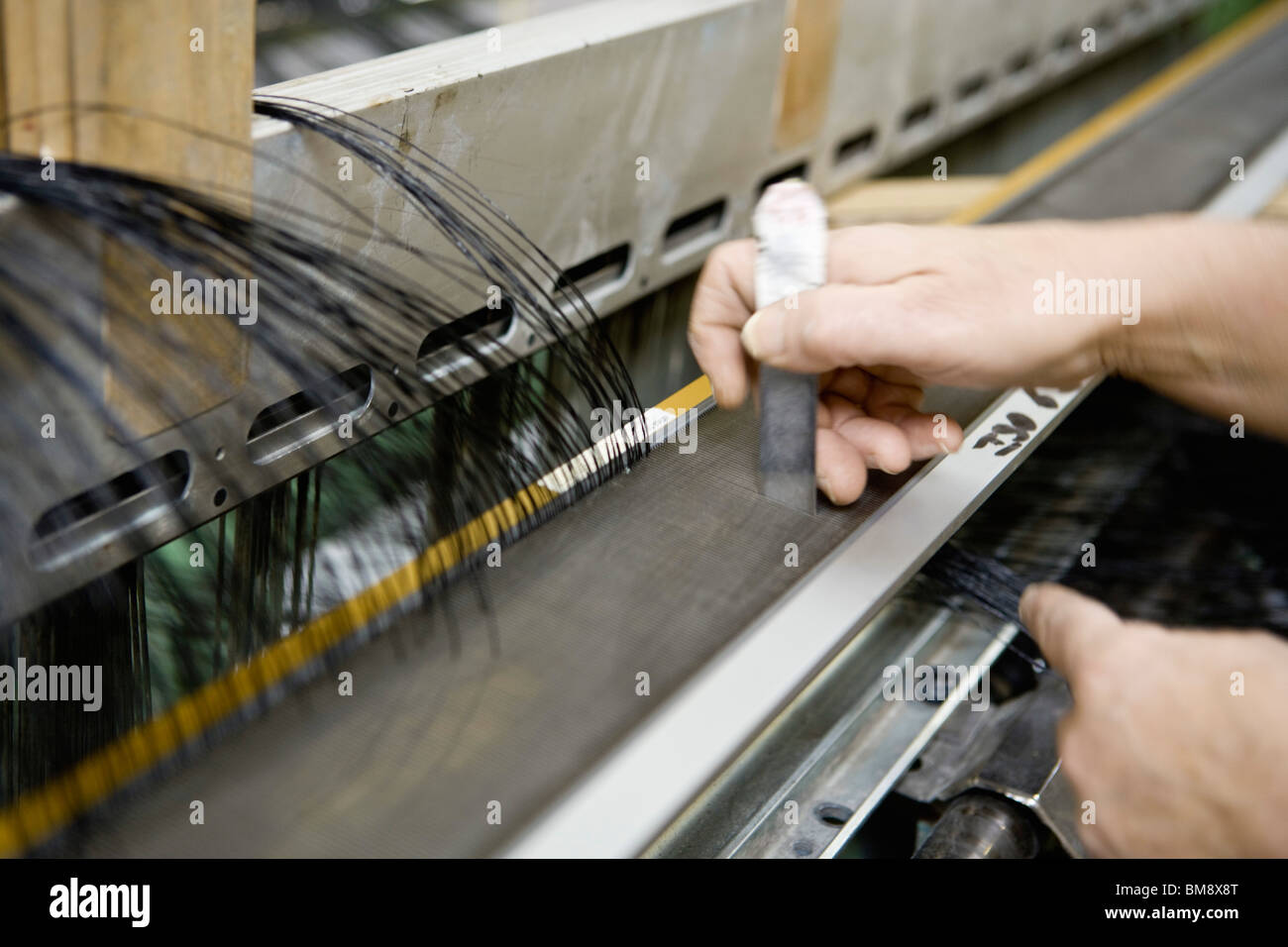 Fabric coating plant, weaving department, mechanist preparing weaver's ...