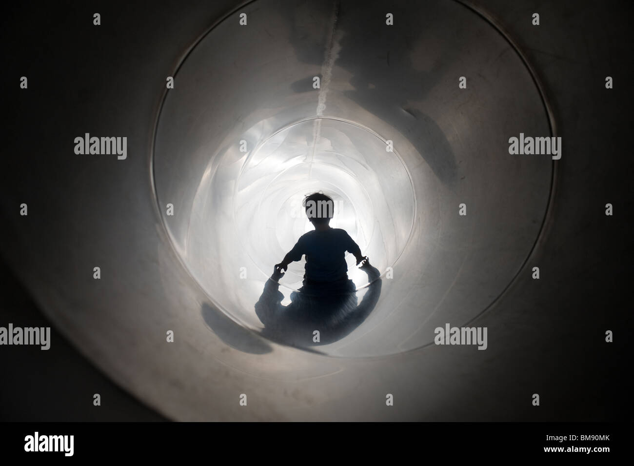 young child sliding down a tunnel slide in north yorkshire Stock Photo ...