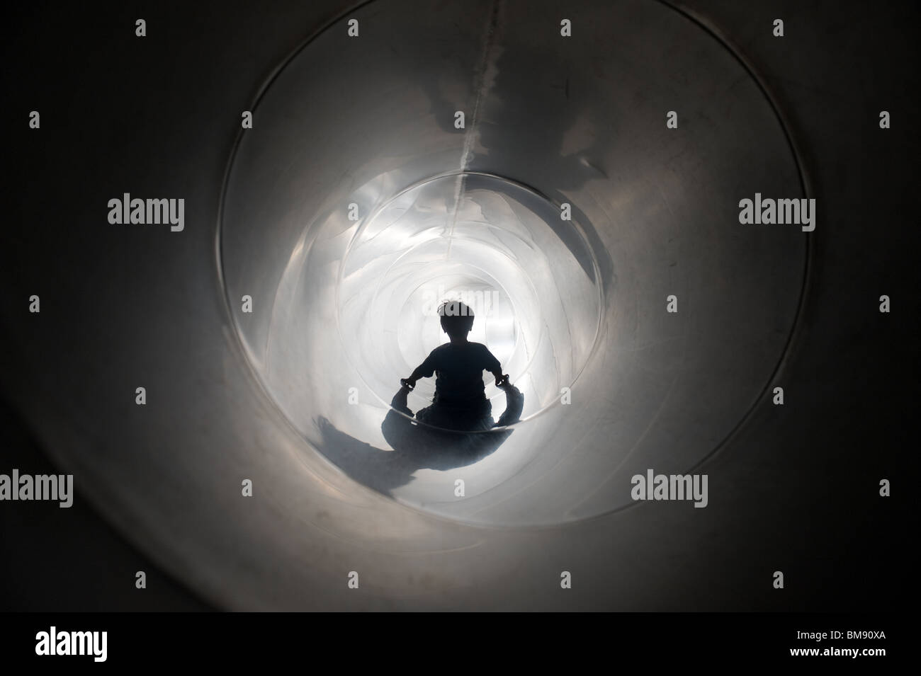 young child sliding down a tunnel slide in north yorkshire Stock Photo ...