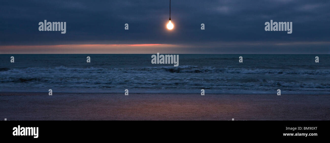 Light bulb illuminated over beach at sunset Stock Photo - Alamy