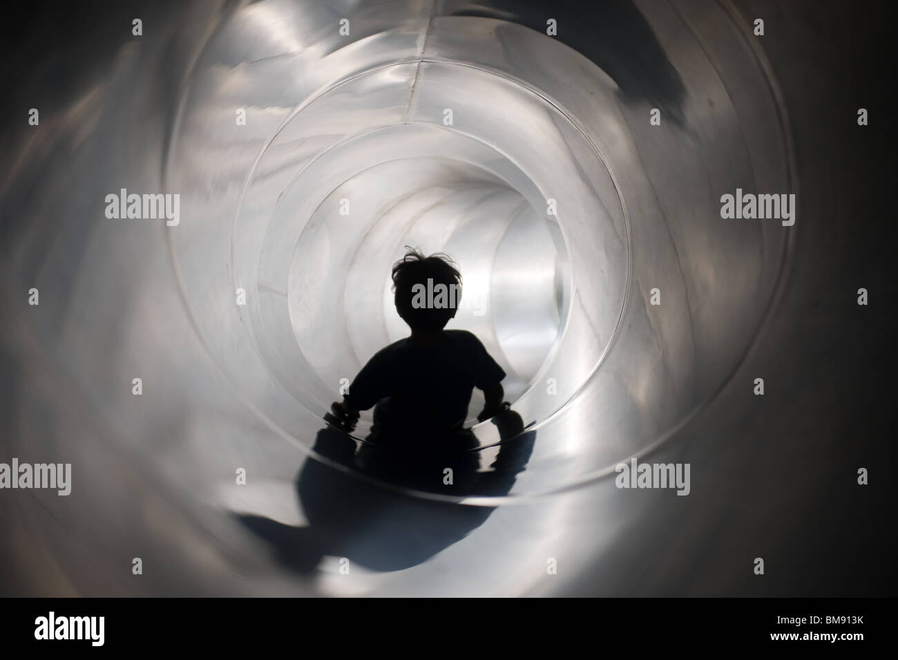 young child sliding down a tunnel slide in north yorkshire Stock Photo ...
