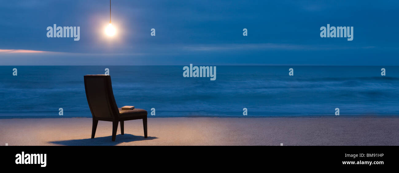 Light bulb illuminated over chair on beach at night Stock Photo - Alamy