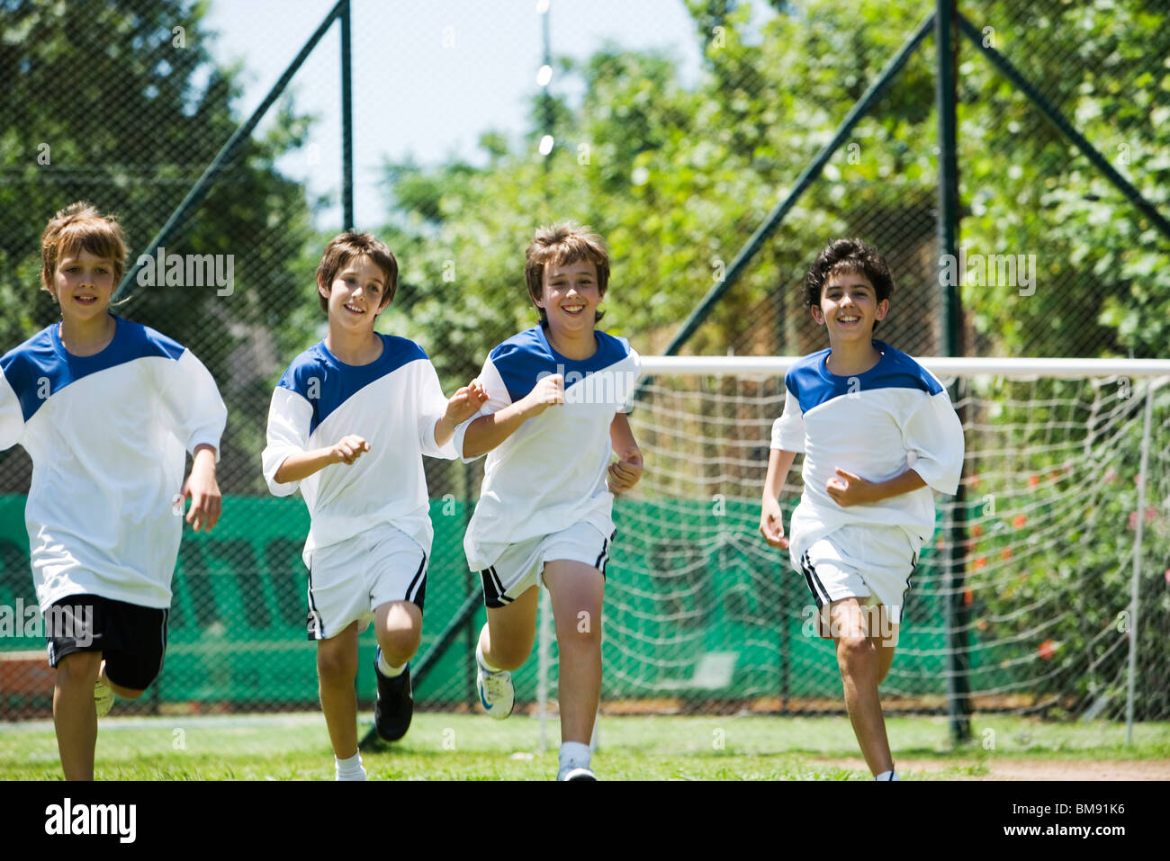 Boys running on soccer field Stock Photo - Alamy