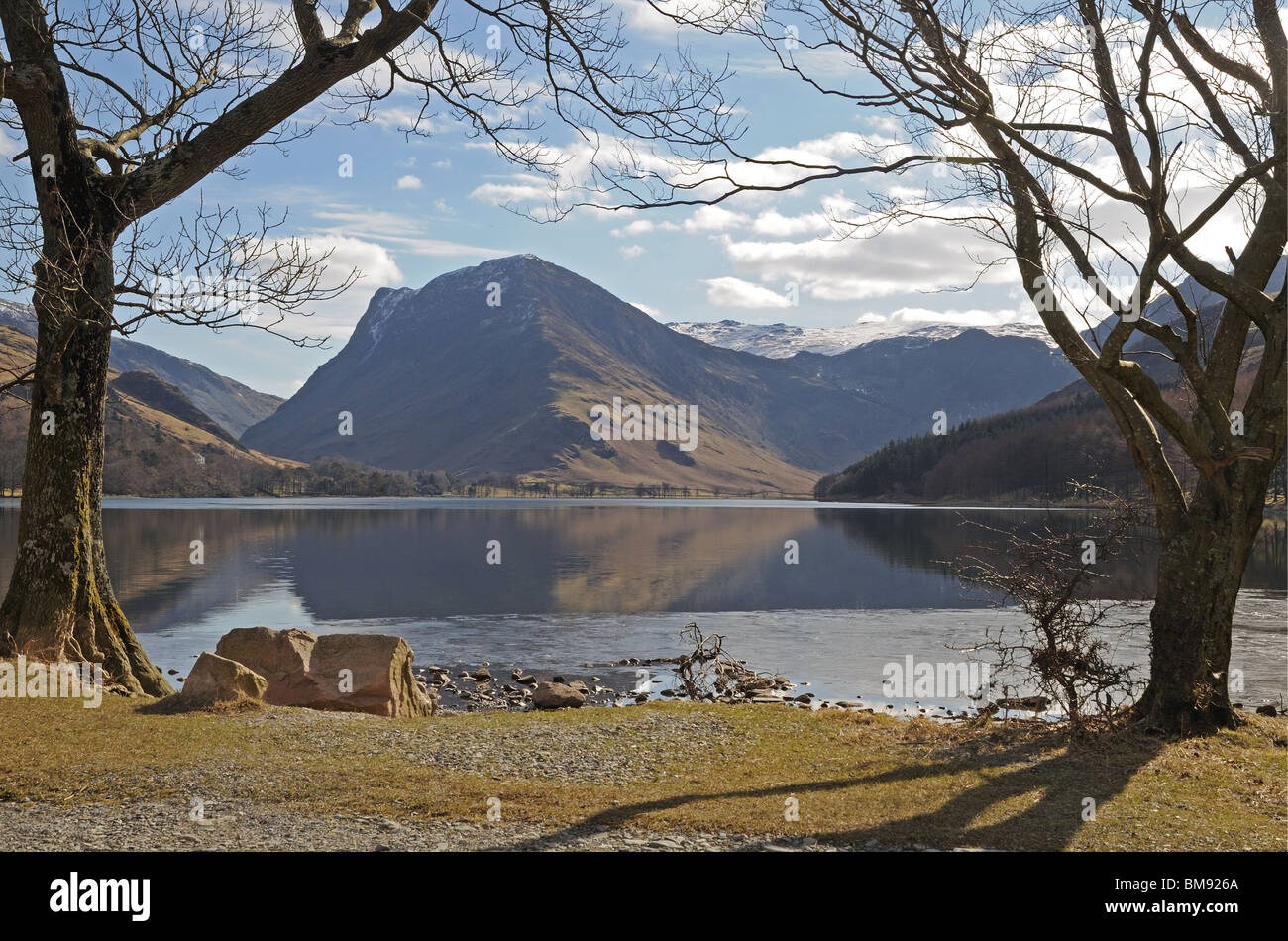 Buttermere Lake and valley with Fleetwith Pike seen through trees at ...