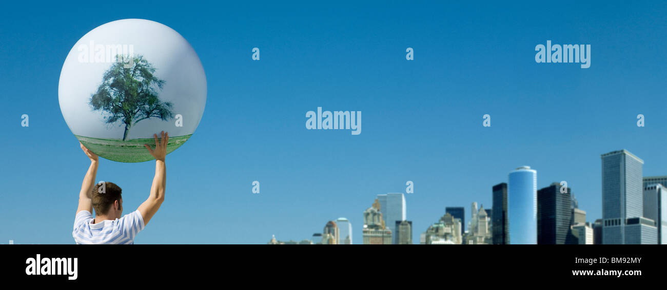 Holding aloft globe displaying image single tree, city skyline in ...