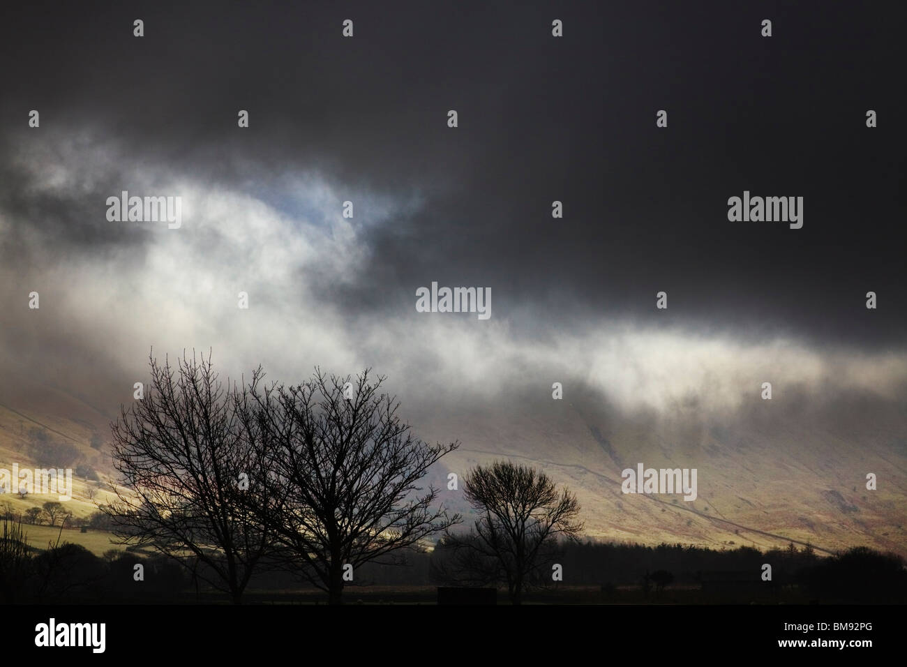 A dramatic image capturing bright shafts of light on the slopes of ...