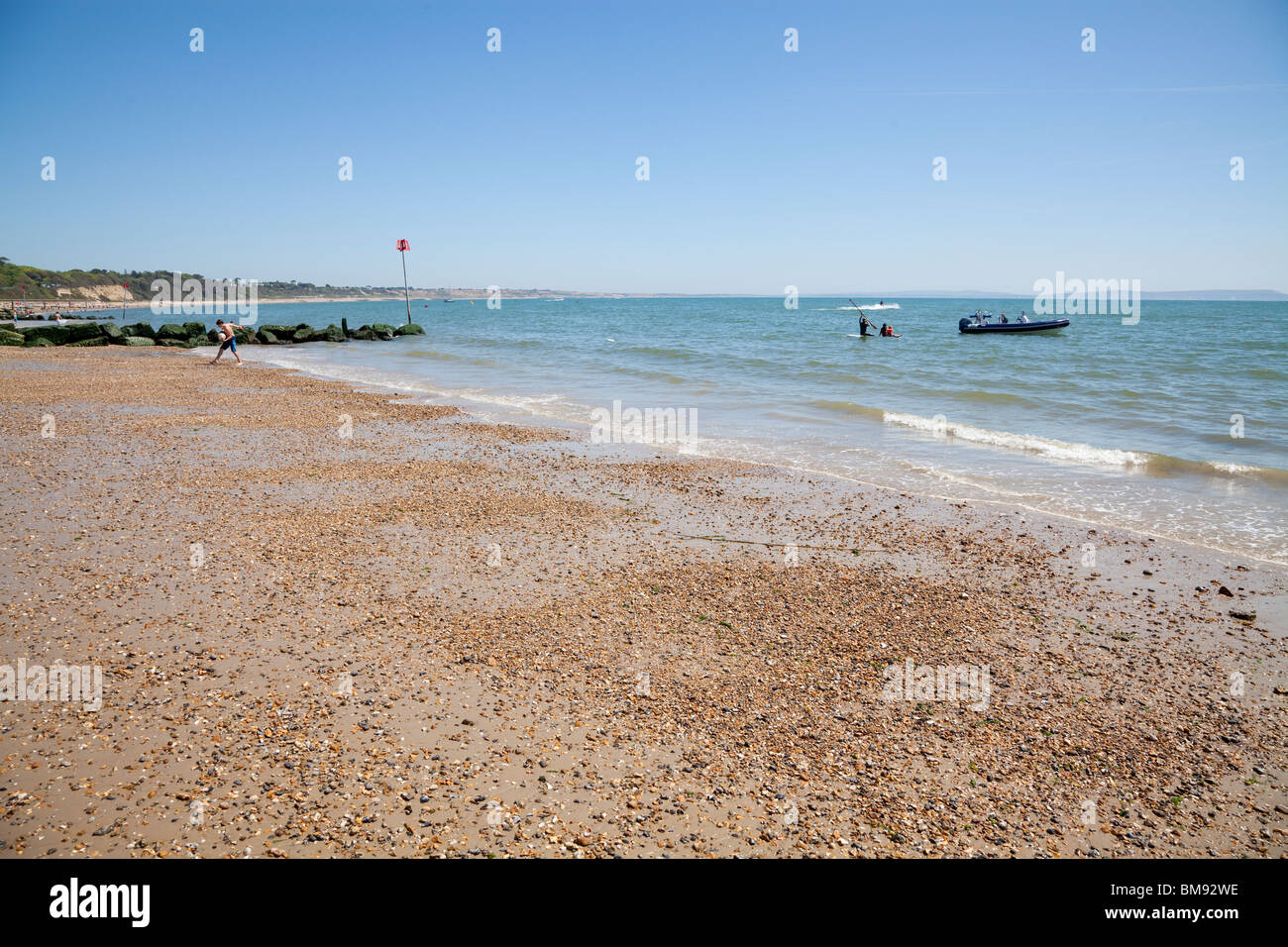 pebble beach with stone groyne and motor boat Stock Photo - Alamy