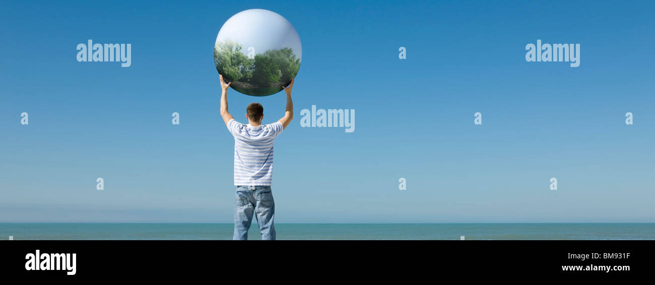 Holding aloft globe displaying image of trees Stock Photo - Alamy