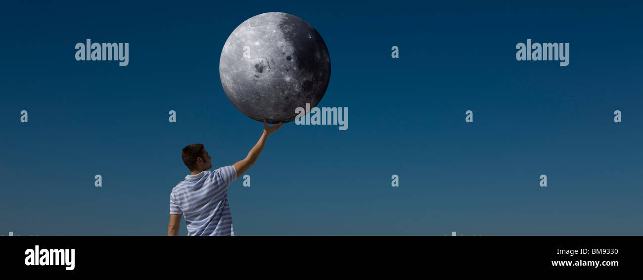 Ecology concept, man holding the moon Stock Photo - Alamy