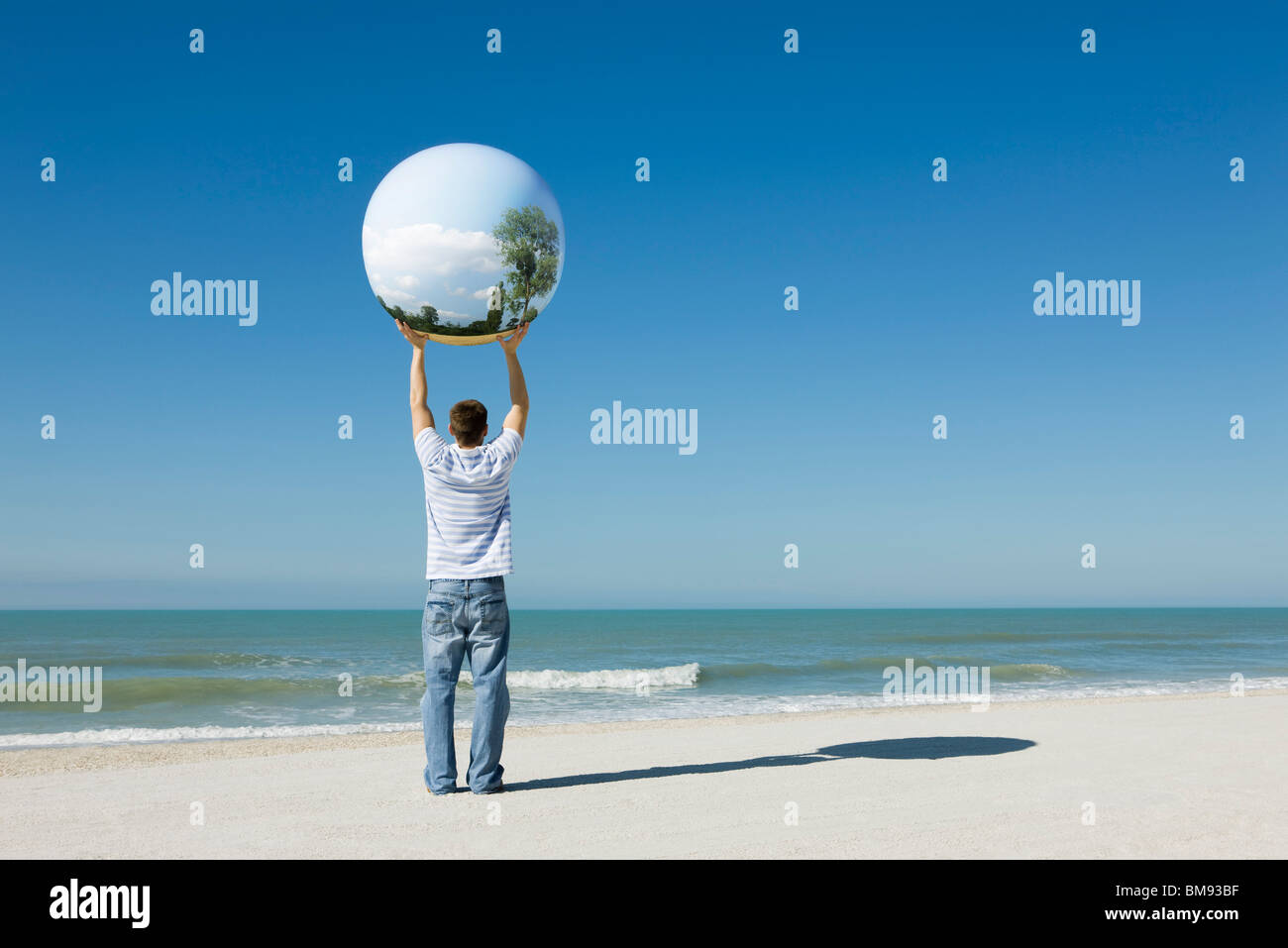 Holding aloft globe displaying image of trees Stock Photo - Alamy