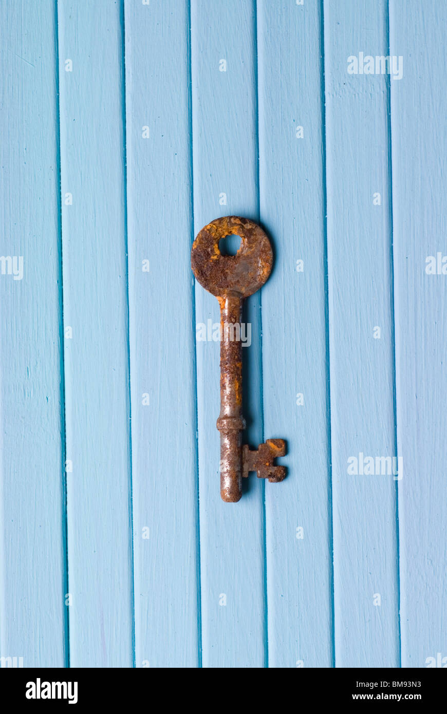 Old rusty skeleton key on a blue wooden background Stock Photo - Alamy