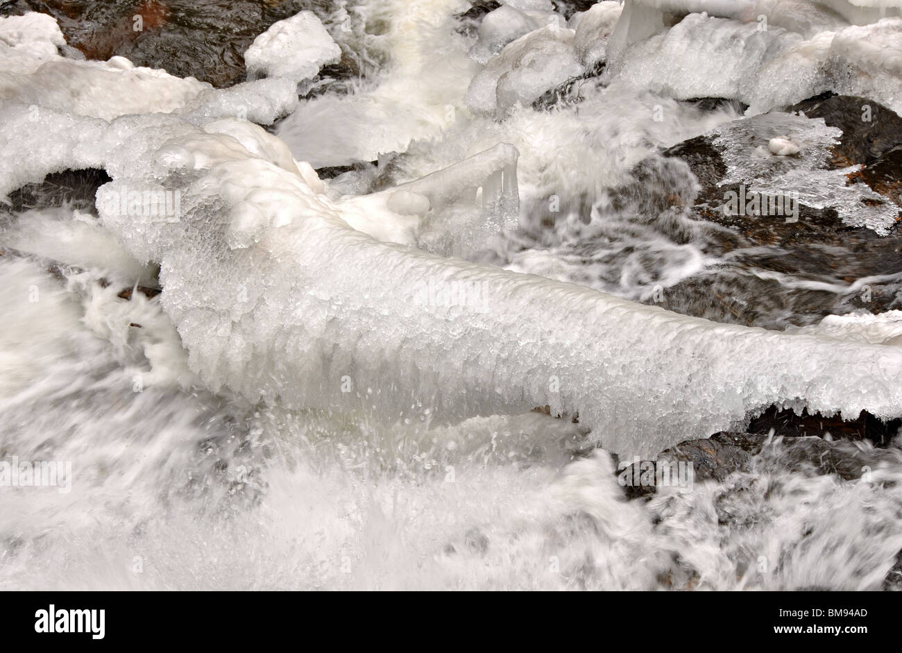 Ice bubbles forming on log over rushing water Stock Photo - Alamy