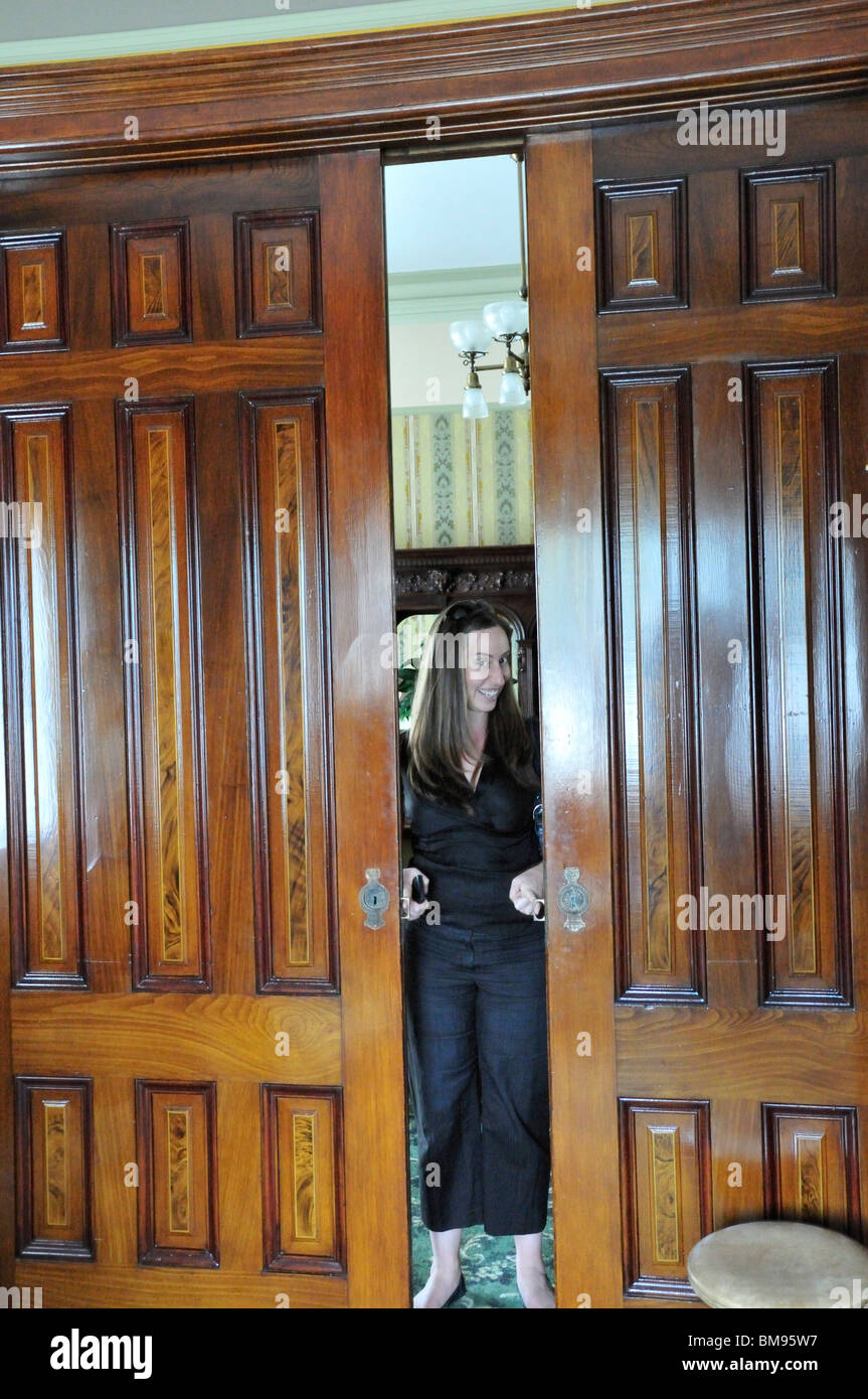Jen Eastwood closes the polished wood doors separating the living room ...