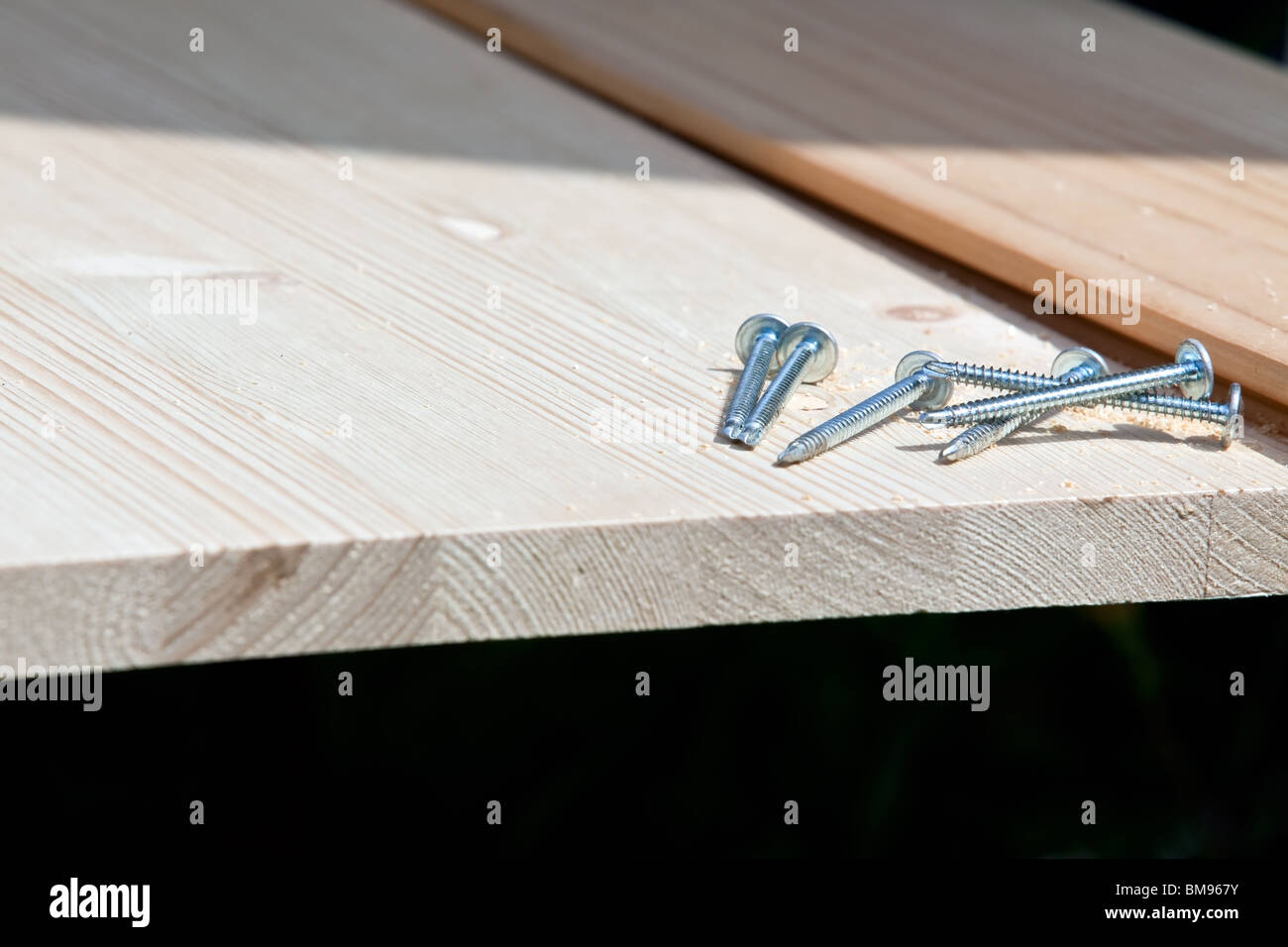 six steel screws on a wooden plank. horizontal closeup shot Stock Photo ...