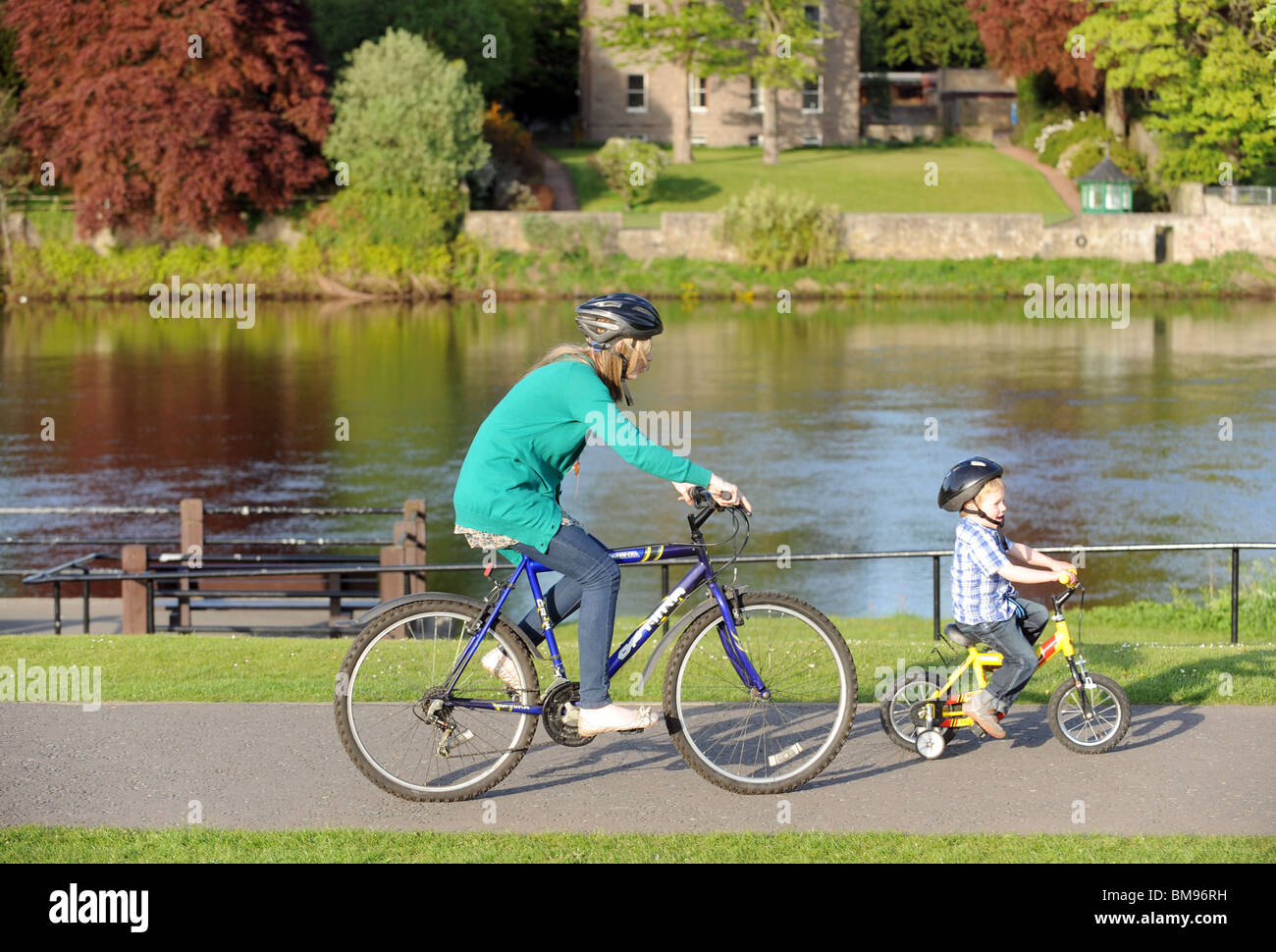 Mother and child cycle along the riverside Stock Photo - Alamy
