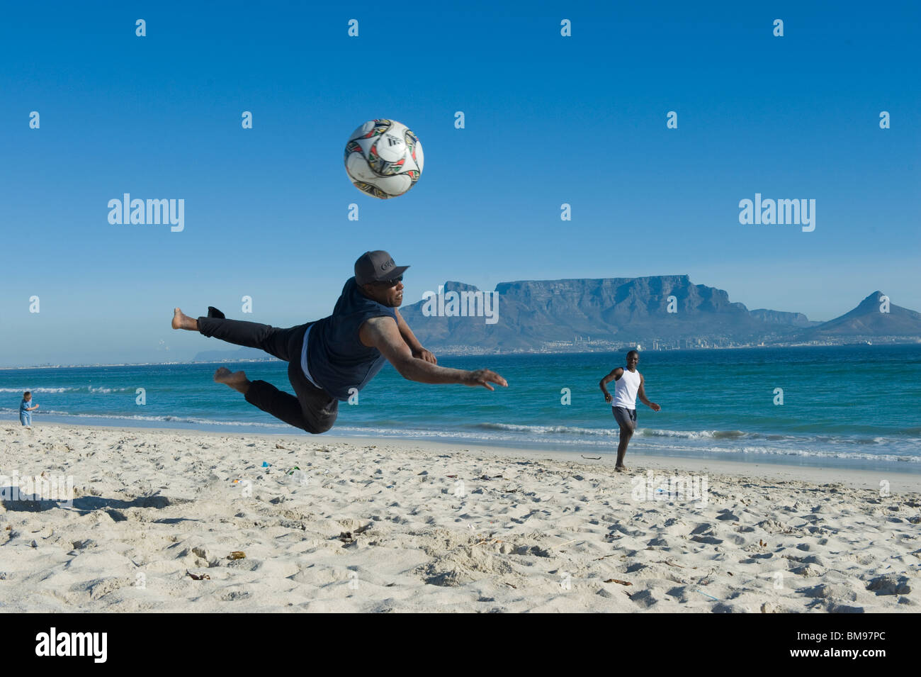 Young man playing football on the beach in Bloubergstrand Cape Town ...