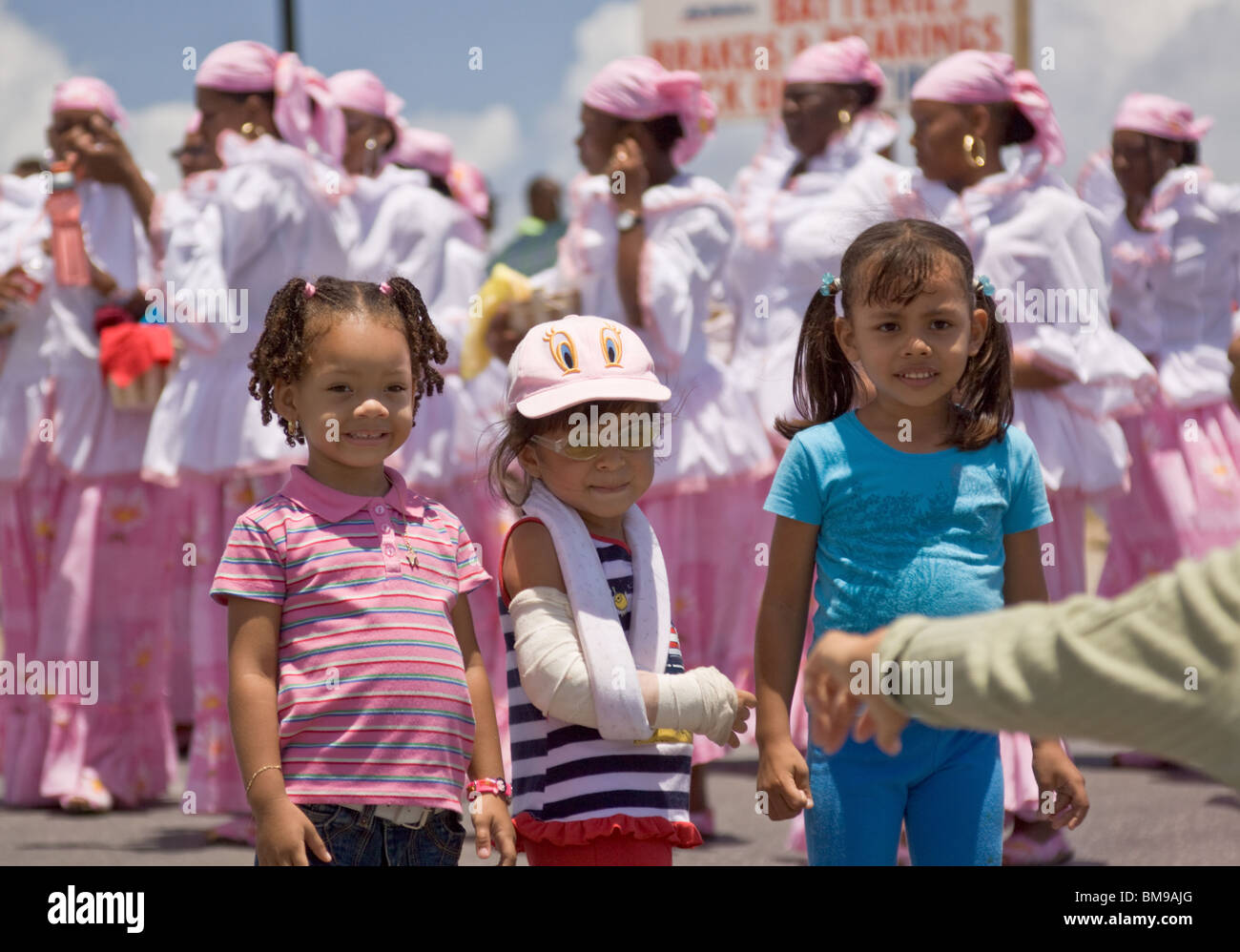 Three children being lined up by their parents during Harvest Festival ...