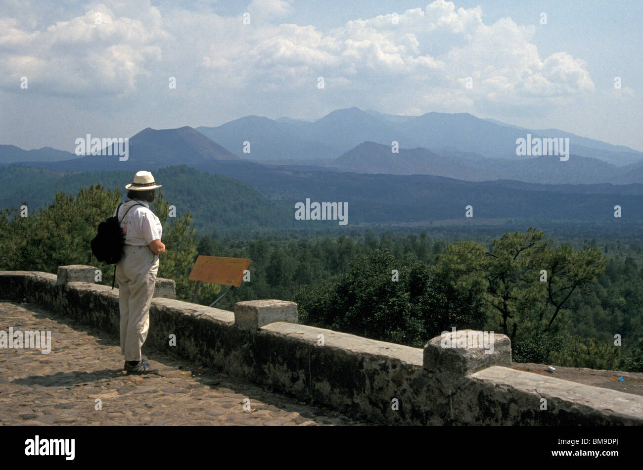 Tourist looking out over lava fields towards Volcan Paricutin volcano ...