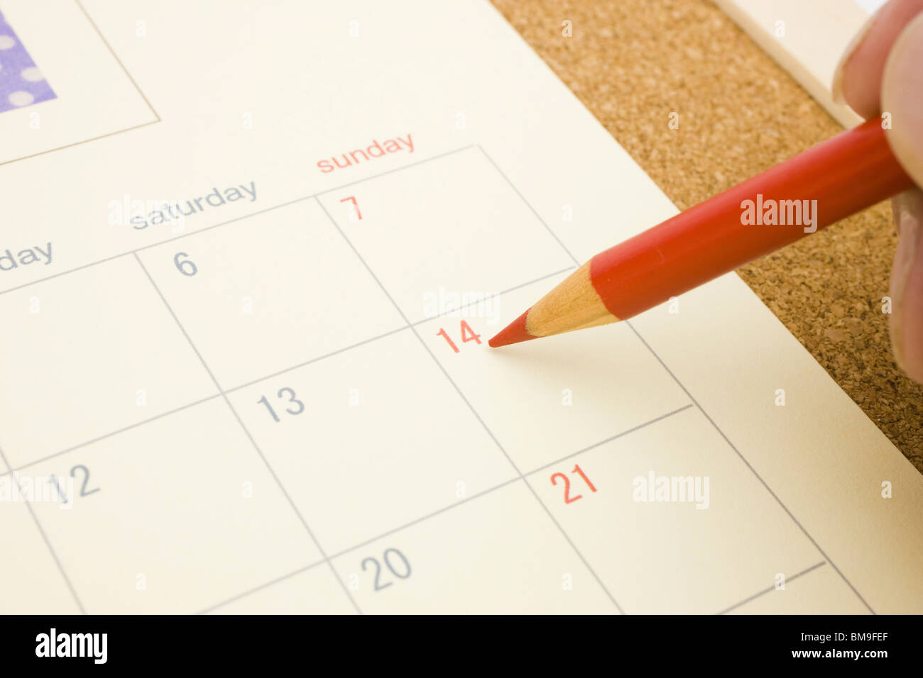 Hand writing on calendar with red pencil close up Stock Photo - Alamy