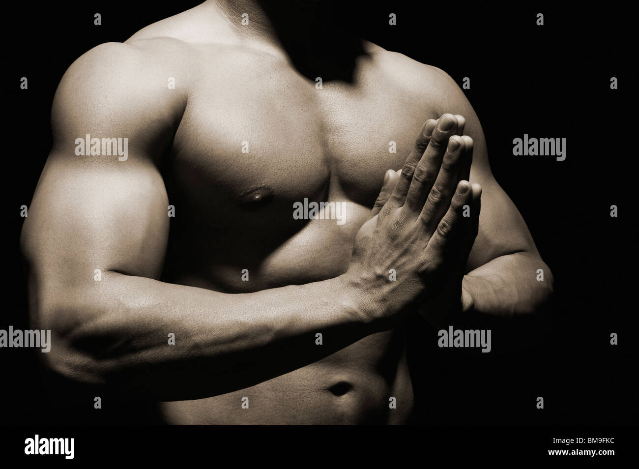 Mid section view of a muscular man meditating Stock Photo - Alamy