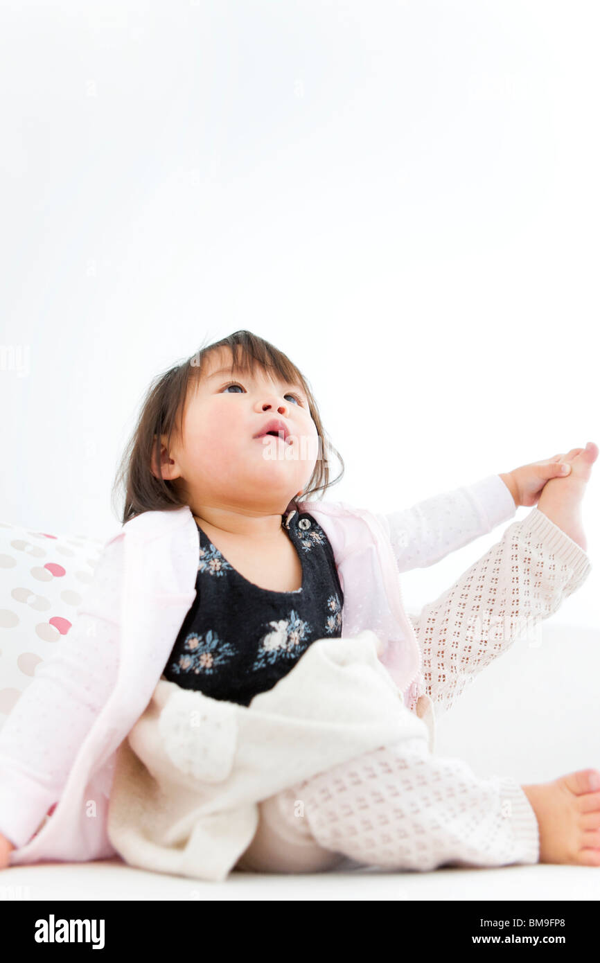 Baby girl stretching on sofa Stock Photo - Alamy