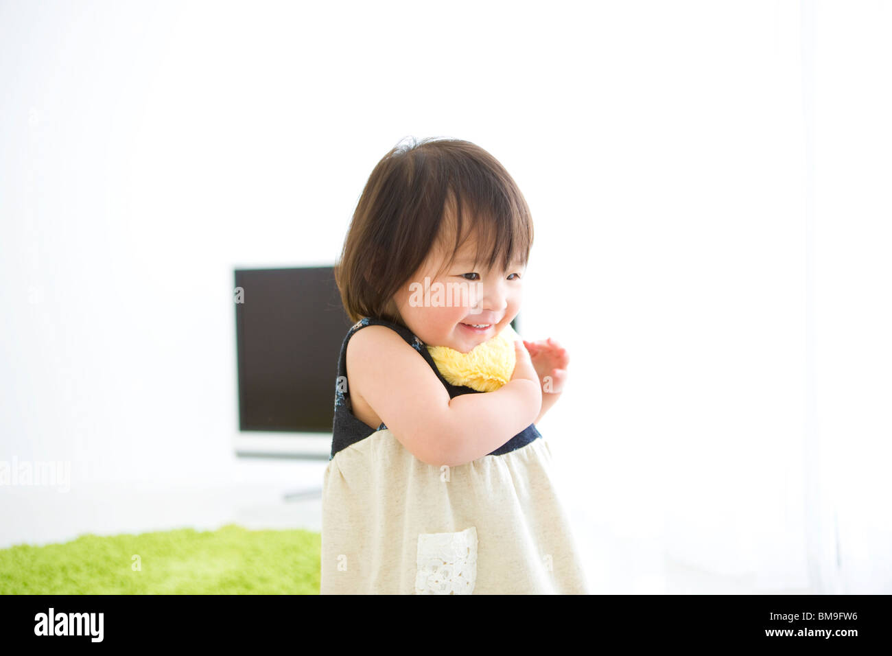 Baby girl standing and smiling Stock Photo - Alamy