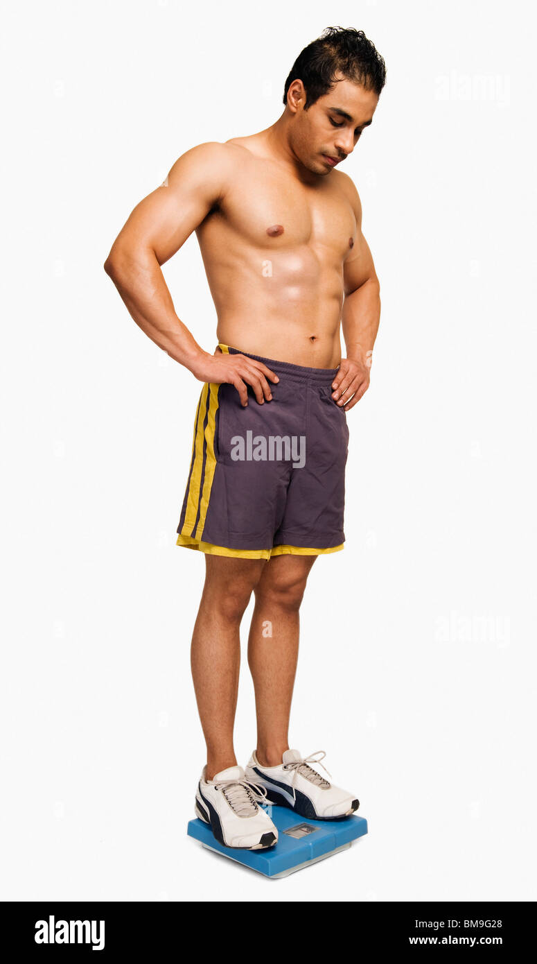 Man standing on a weight scale Stock Photo - Alamy