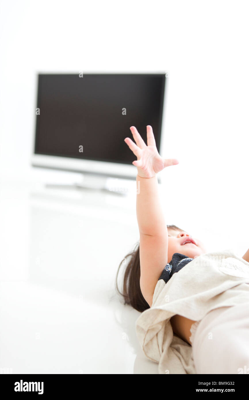 Baby girl lying on back and arms raised Stock Photo - Alamy